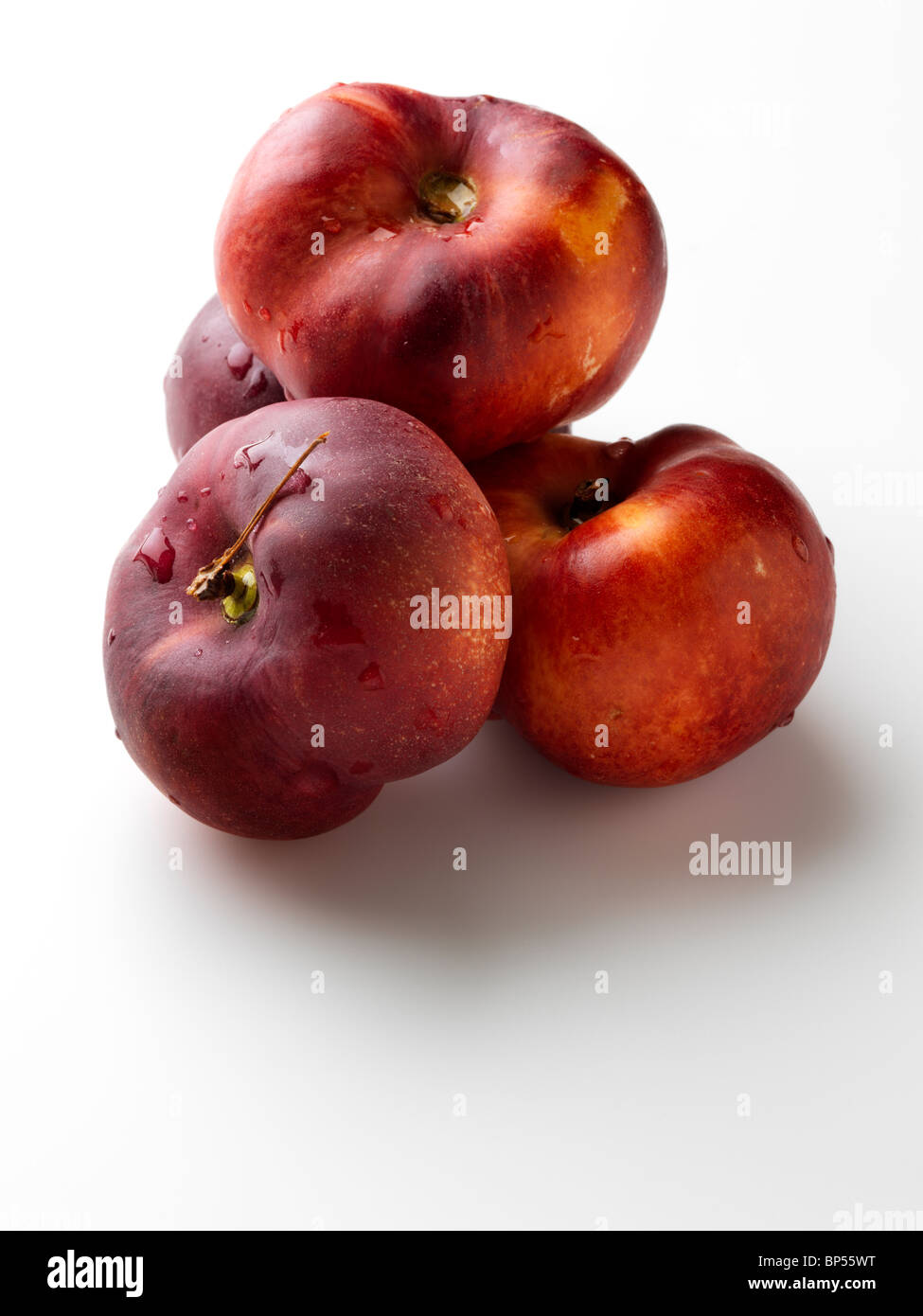 A pile of flat peento nectarines on a white background Stock Photo - Alamy