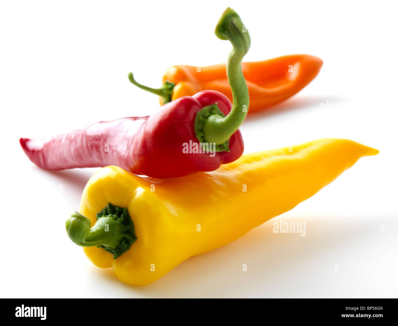 Red yellow orange sweet peppers on a white background Stock Photo - Alamy