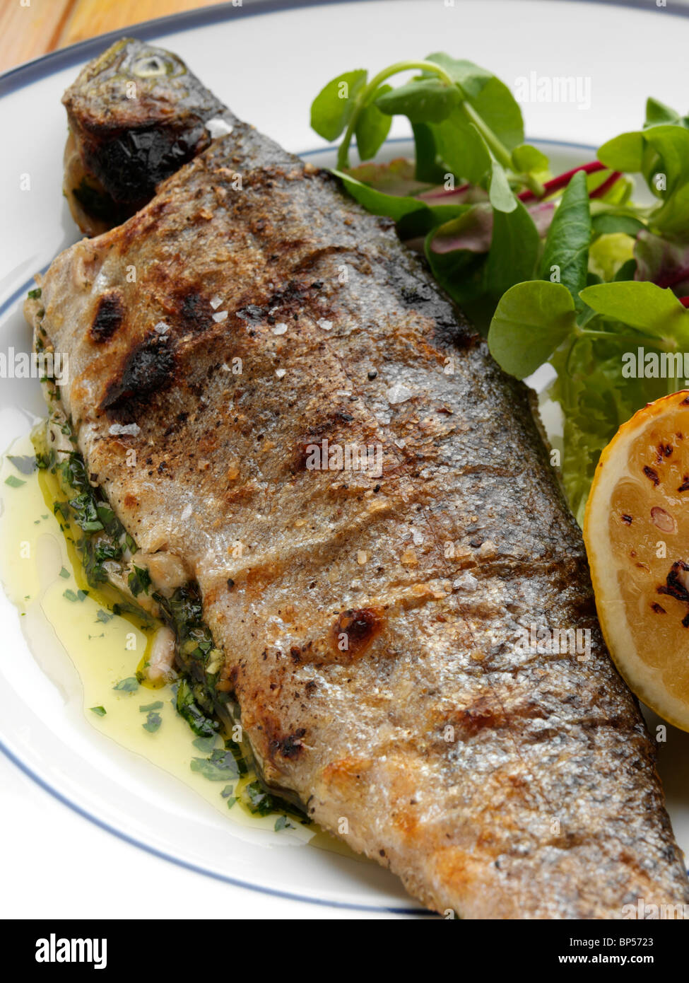 Individual portion of broiled rainbow trout and salad Stock Photo - Alamy