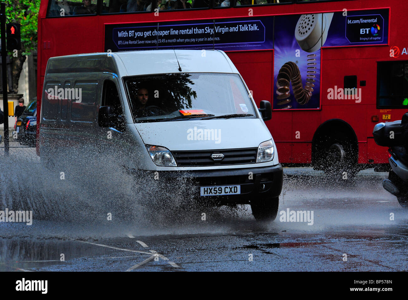 Vehicles driving through puddles making a big splash Stock Photo - Alamy