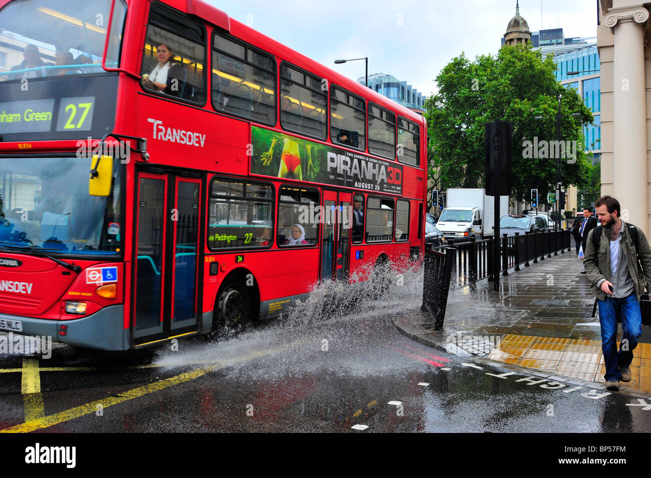 Bus driving through puddle splashing commuter Stock Photo - Alamy