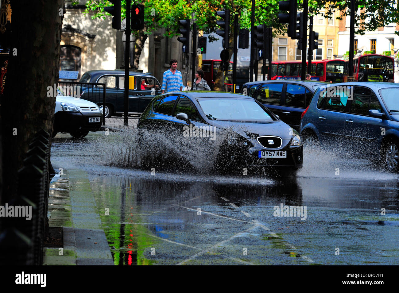 Vehicles driving through puddles making a big splash Stock Photo - Alamy