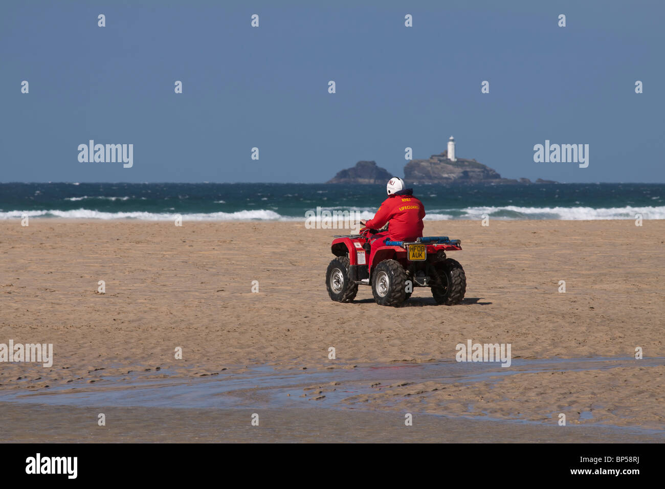 Lifeguard patrolling the sandy beach on a quad bike Stock Photo - Alamy