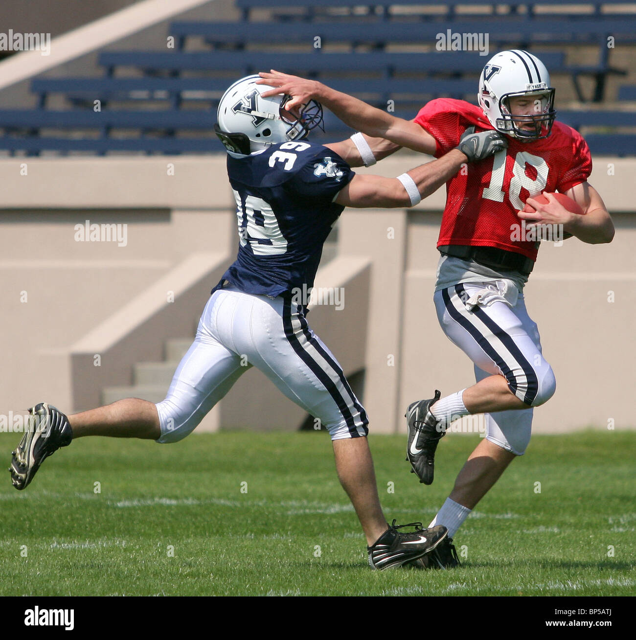 A Yale University receiver gives the "stiff arm" to a defender during a ...