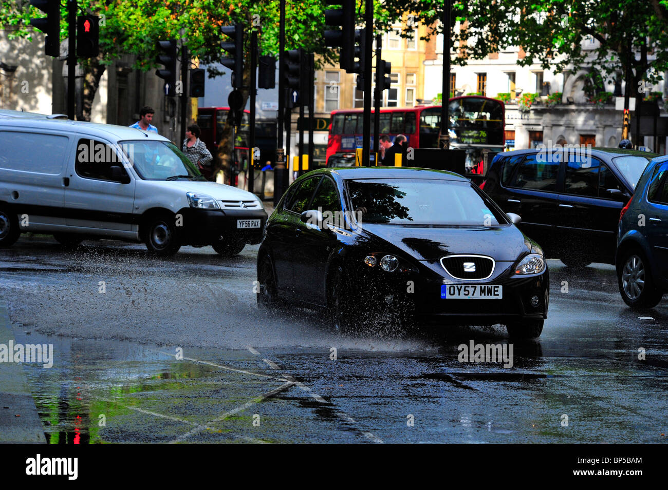 Vehicles driving through puddles making a big splash Stock Photo - Alamy