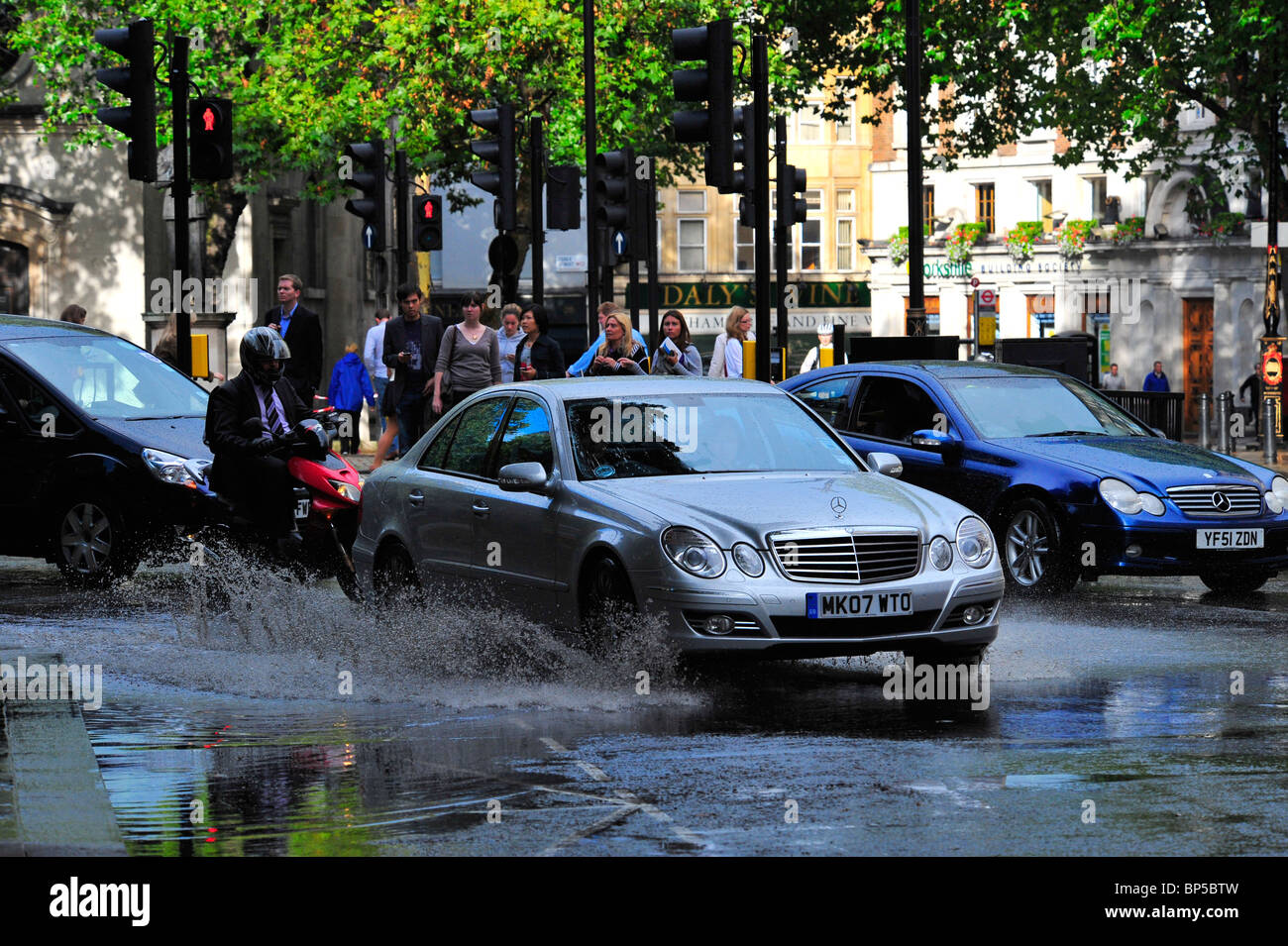 Vehicles driving through puddles making a big splash Stock Photo - Alamy