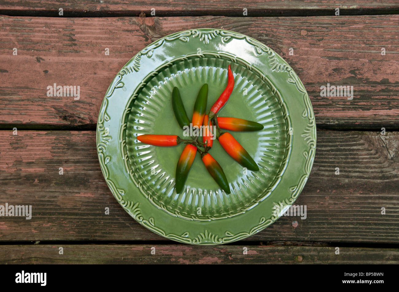 Chile peppers on green ceramic plate Stock Photo - Alamy