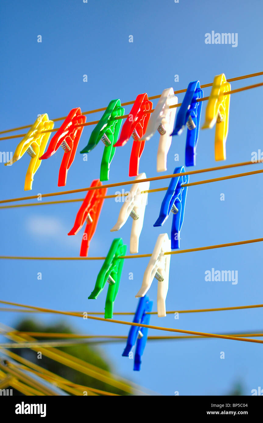 clothes pegs hanging on washing line with blue sky Stock Photo - Alamy