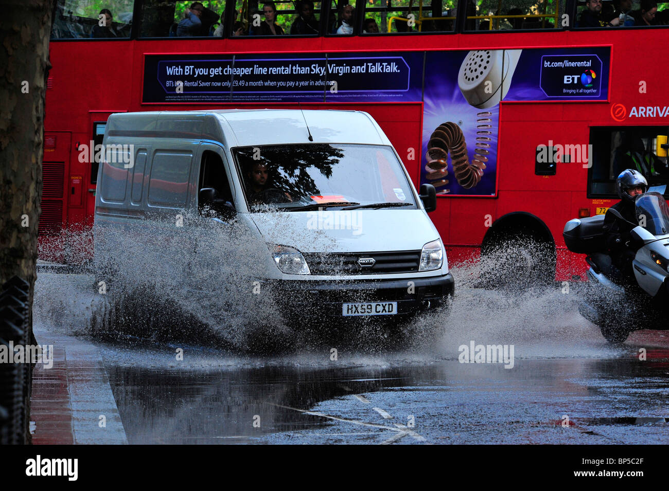 Vehicles driving through puddles making a big splash Stock Photo - Alamy