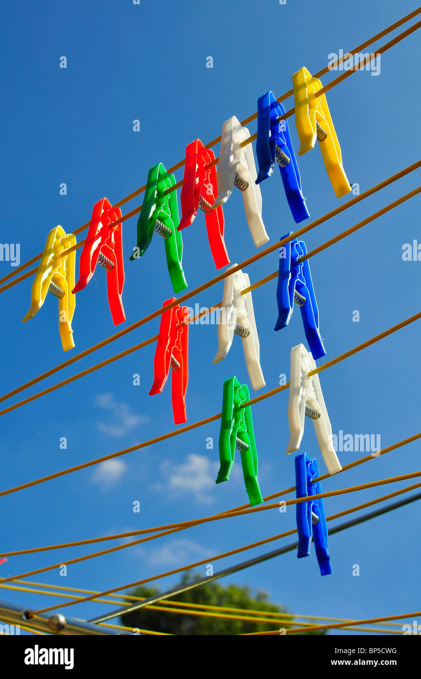 clothes pegs hanging on washing line with blue sky Stock Photo - Alamy