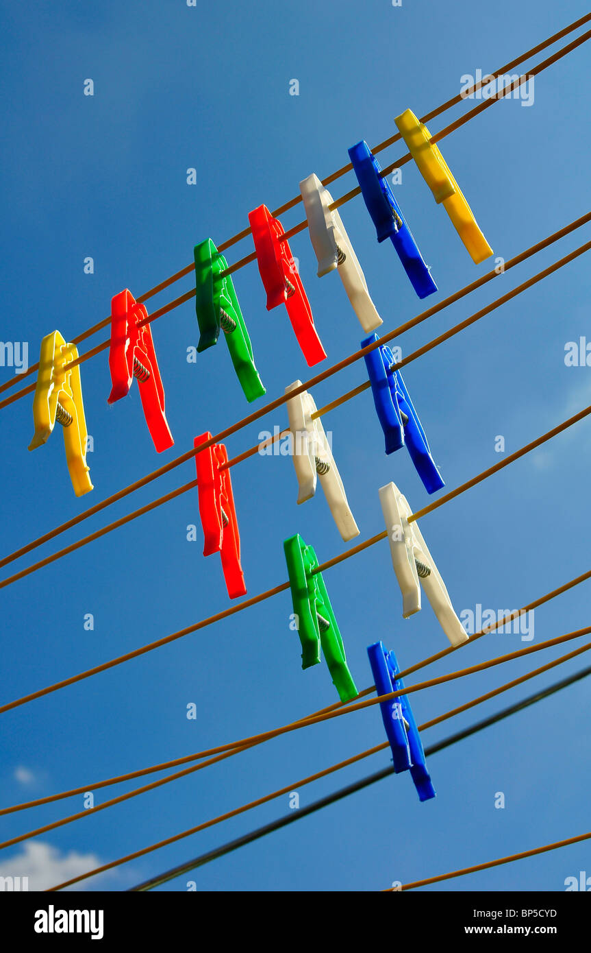 clothes pegs hanging on washing line with blue sky Stock Photo - Alamy