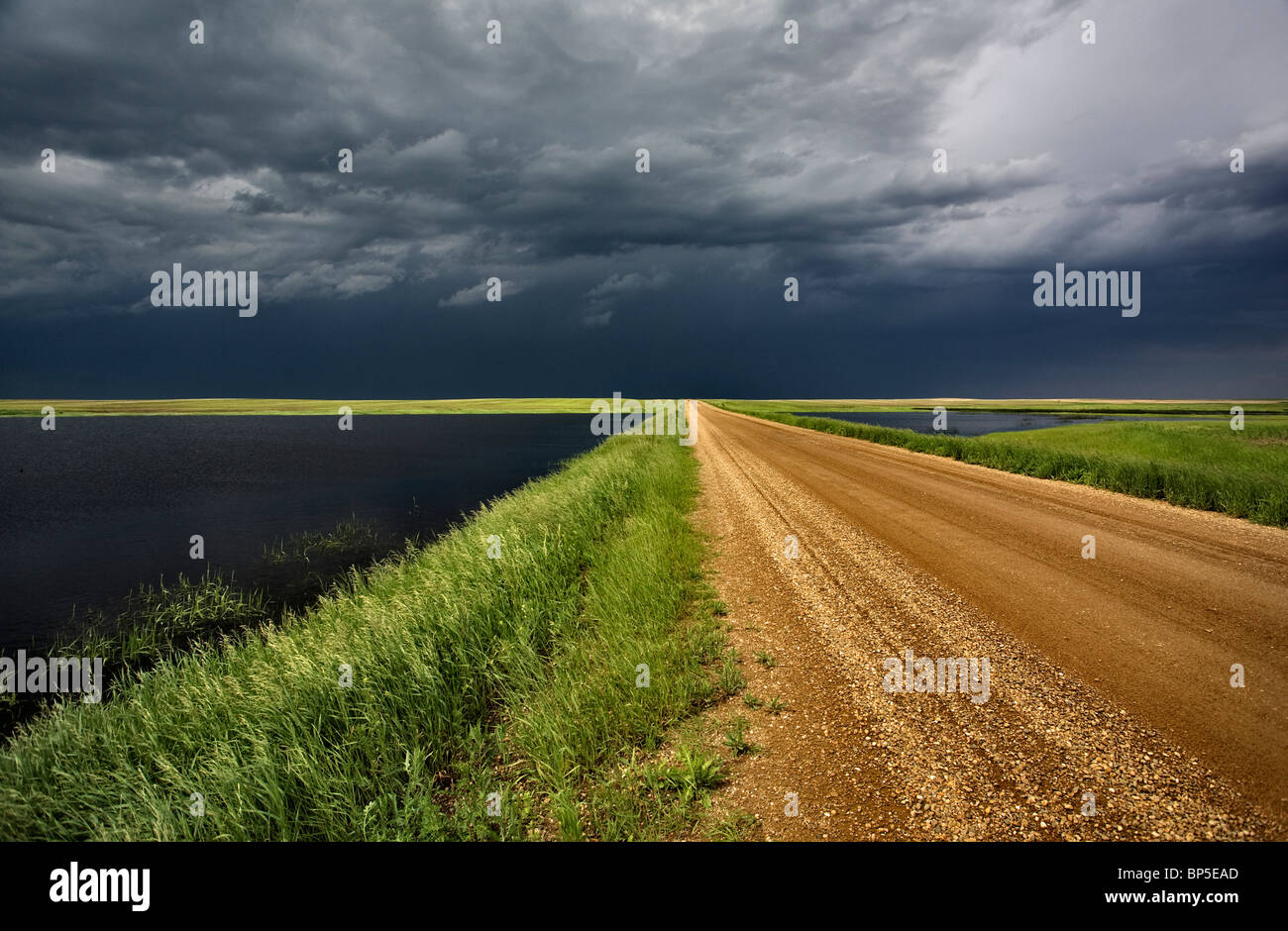 Storm Clouds over Prairie slough and road Stock Photo - Alamy