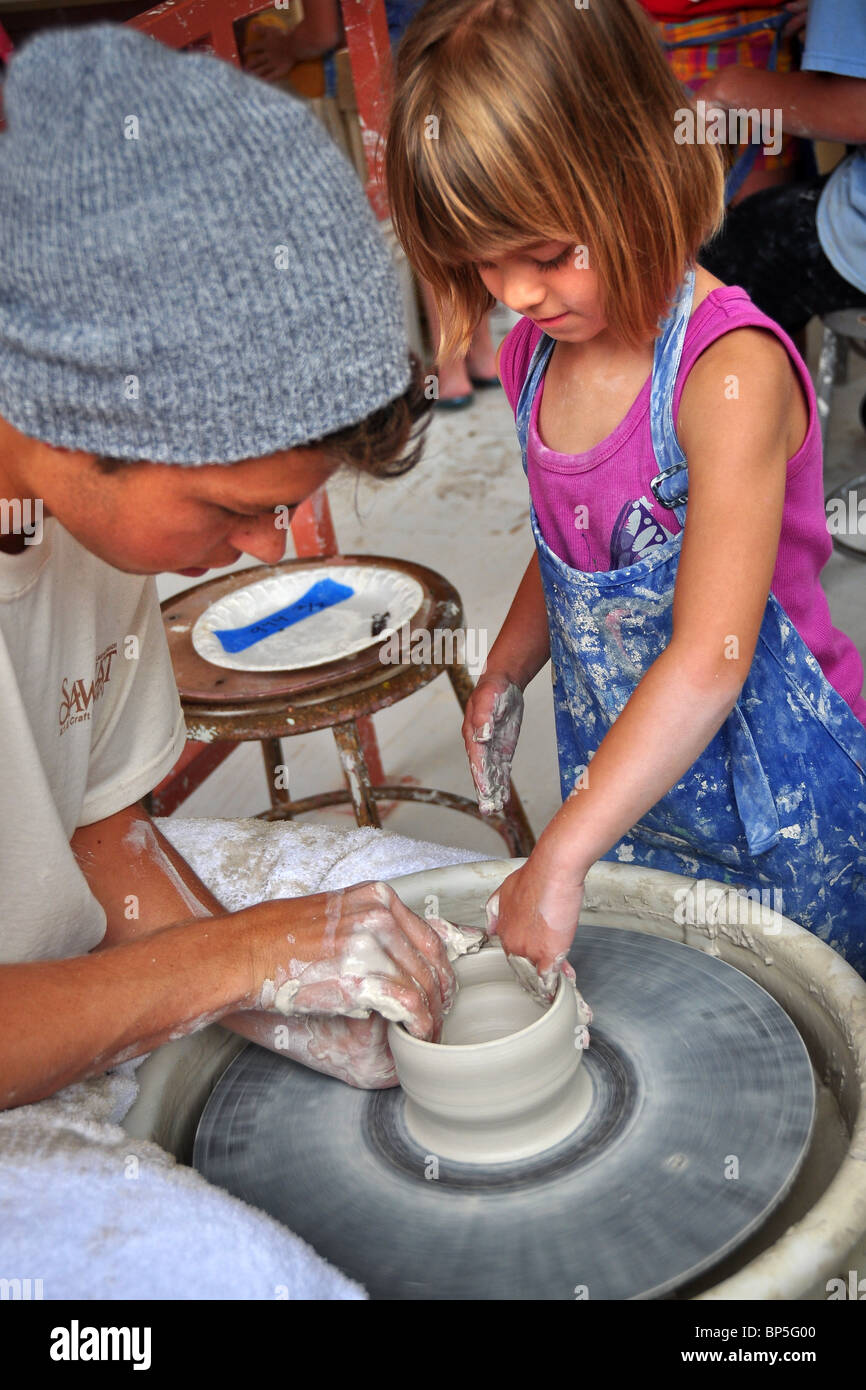 Teen boy teaches young girl how to make a ceramic pot Stock Photo - Alamy