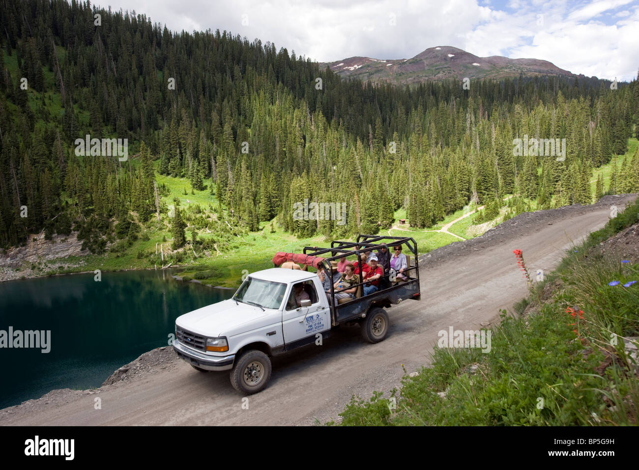 Summertime view tourists riding in an Alpine Express touring truck at ...