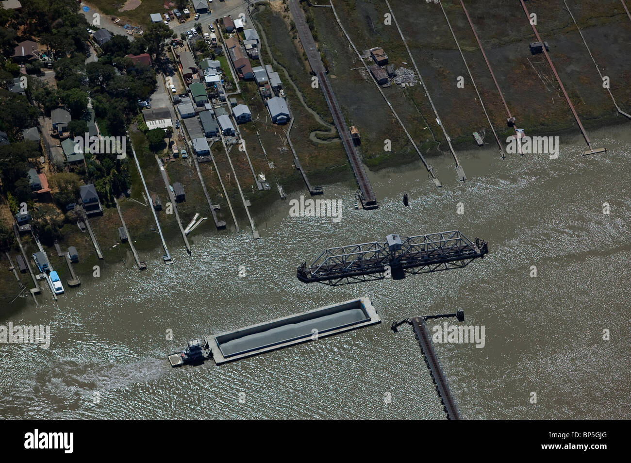 aerial view above tug boat pushing barge approaching swing bridge ...