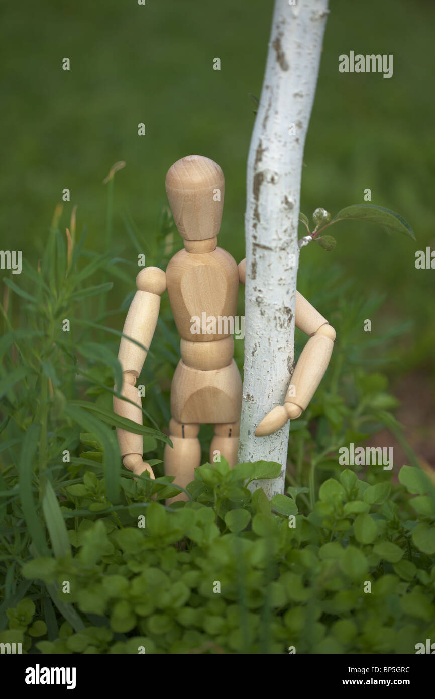 Little wooden toy man hugging a tree Stock Photo - Alamy