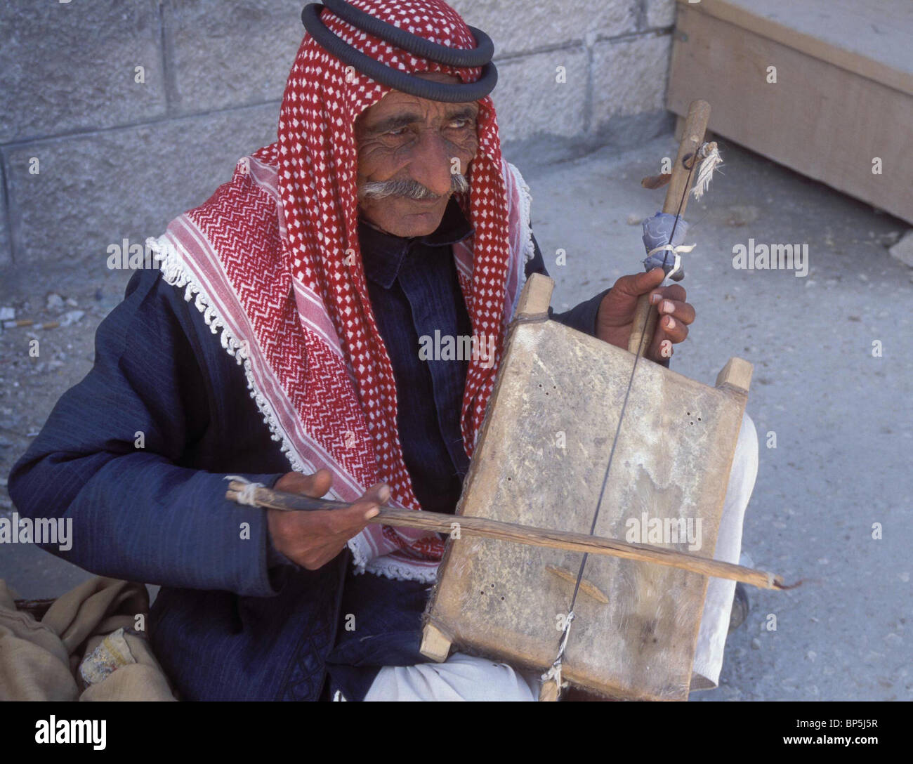 3594. AN OLD BEDWI MAN PLAYING THE "RABABA", AN ONE STRINGED MUSICAL ...