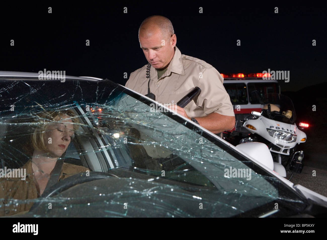 Police officer rescuing car accident victim Stock Photo - Alamy