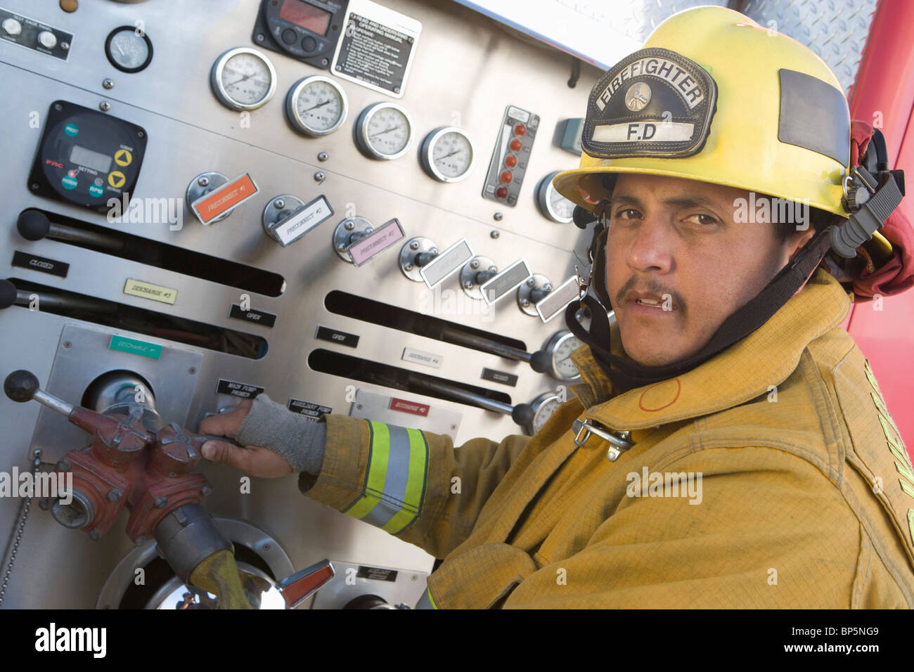 Firefighter at control panel of truck Stock Photo - Alamy