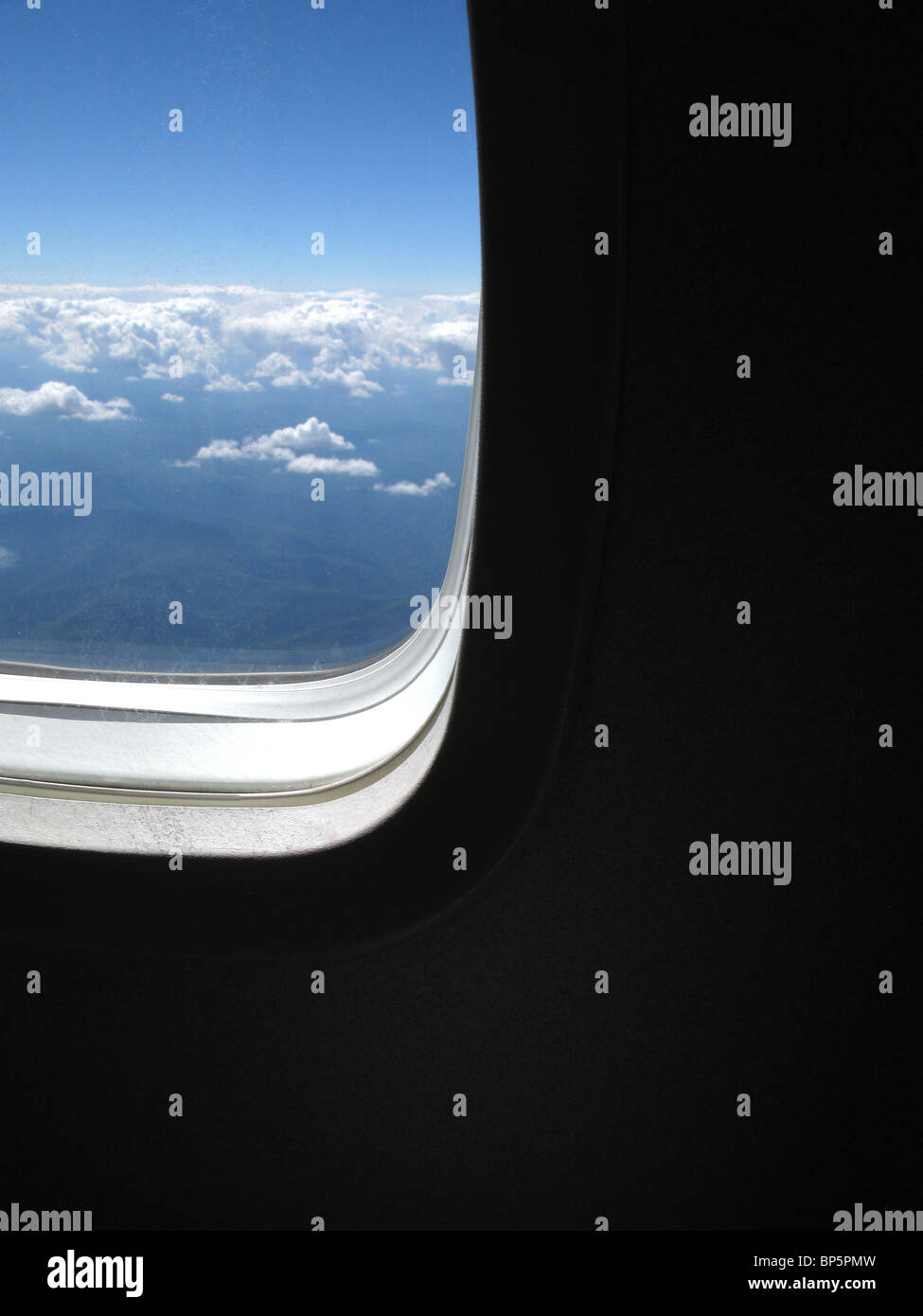 A passenger's view of an airplane's window outside, daylight with blue ...