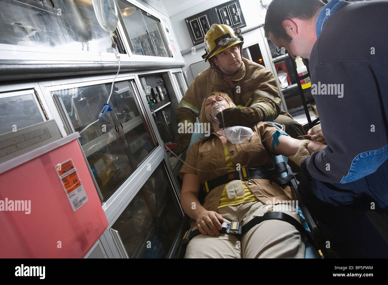 Firefighter and paramedic helping woman in ambulance Stock Photo - Alamy