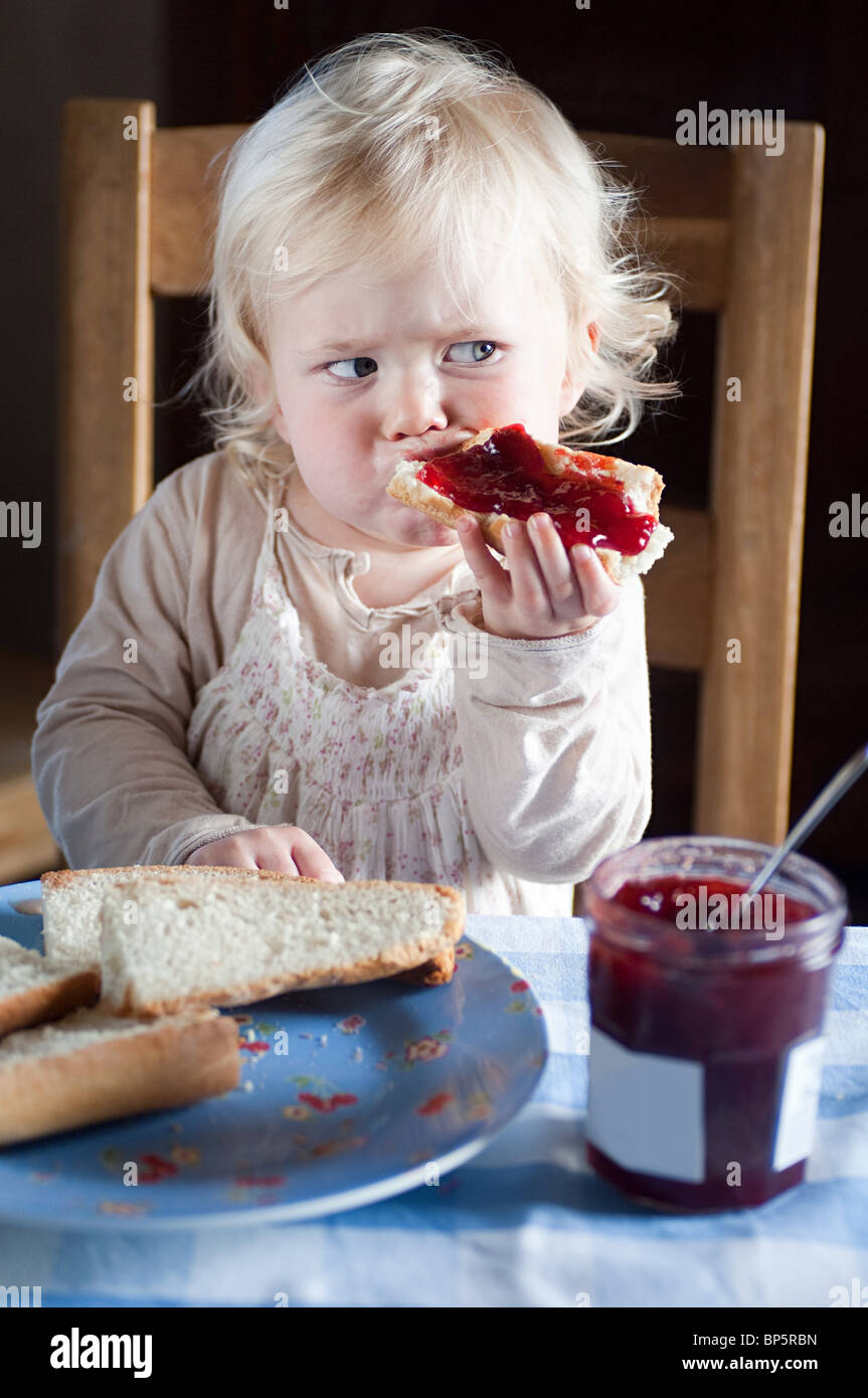 Female toddler eating bread and jam Stock Photo - Alamy
