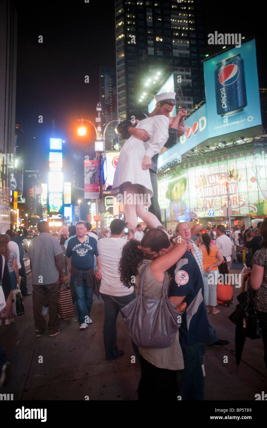 Visitors to Times Square in New York kiss and view the 26 foot tall ...