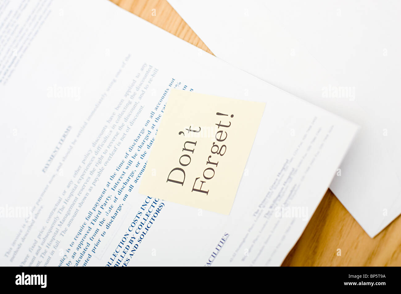 Don't forget written on adhesive note on bill Stock Photo - Alamy