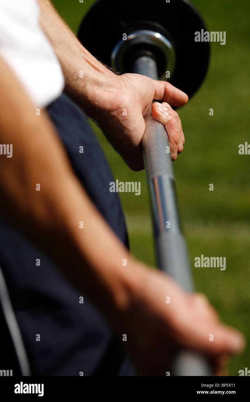 Sport male holding dumbbell bar Stock Photo - Alamy