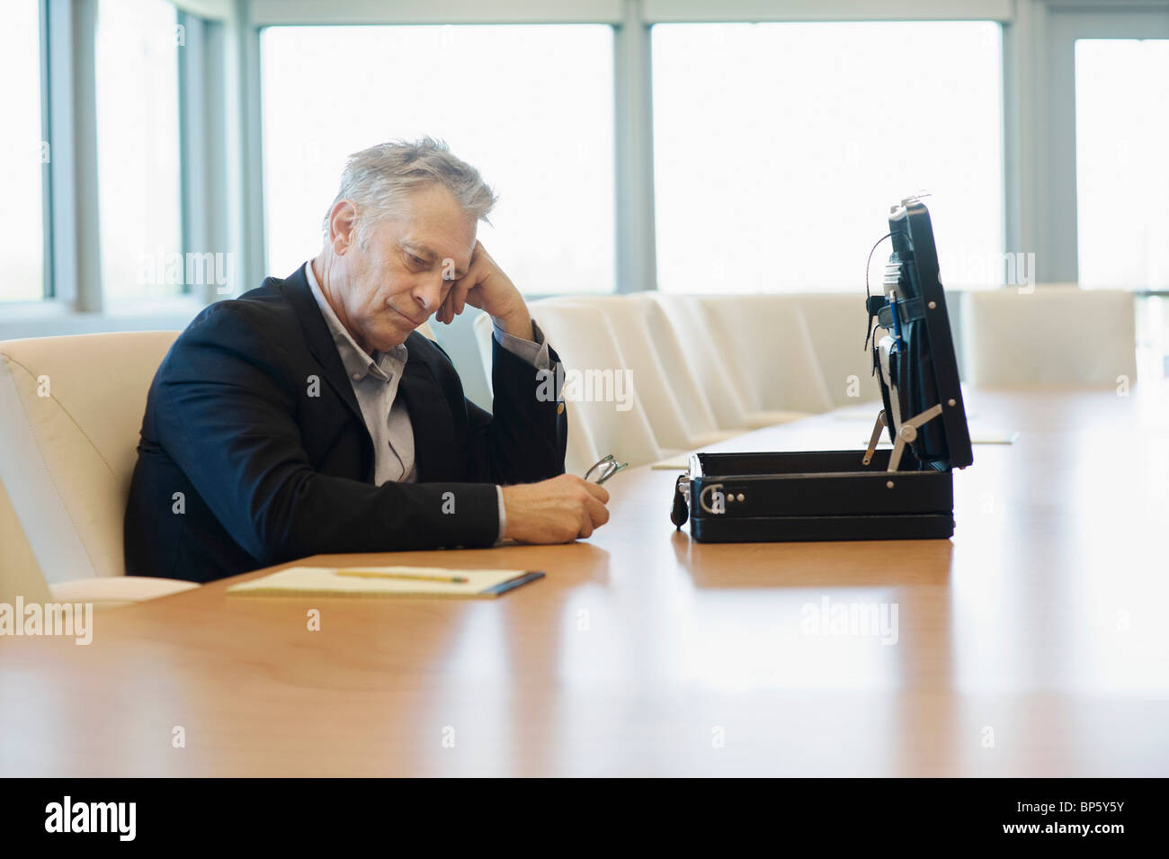 Serious Businessman with Open Briefcase, Hand on Head Stock Photo - Alamy