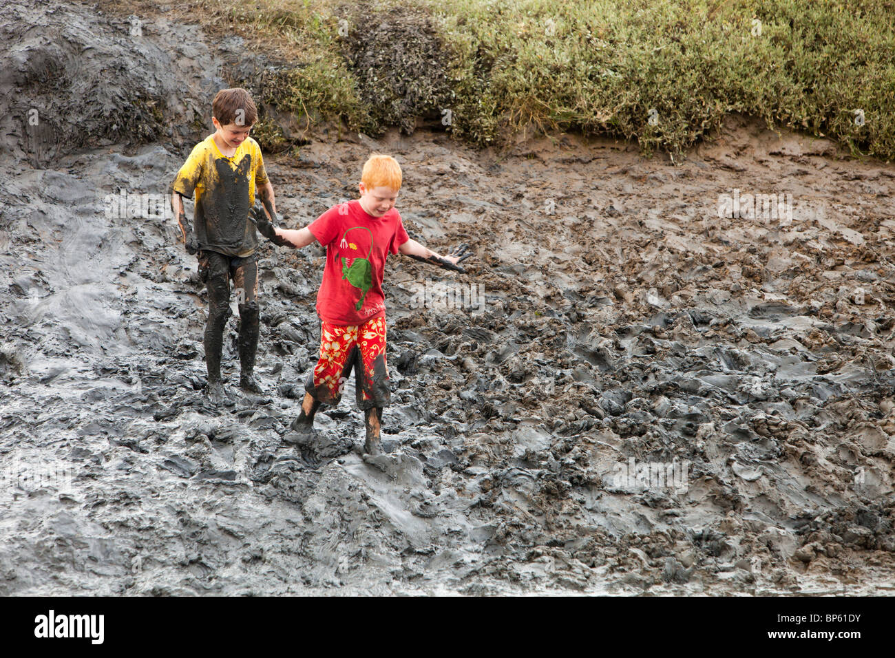 Children playing in a muddy creek at Blakeney, North Norfolk, UK Stock ...
