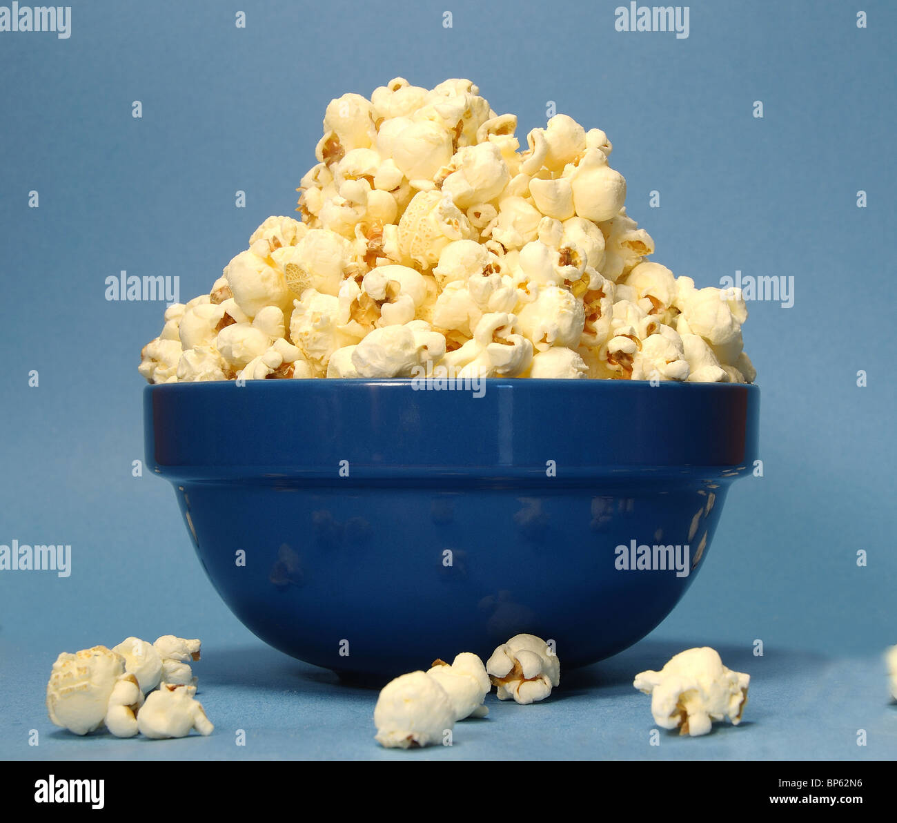 popcorn overflowing small blue bowl Stock Photo - Alamy