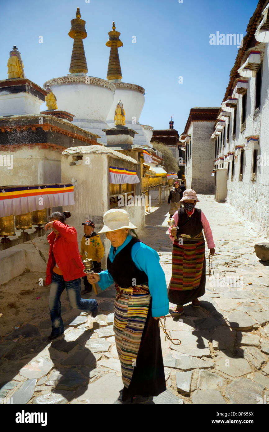 A pilgrim family walk around stupas set in the courtyards of ...