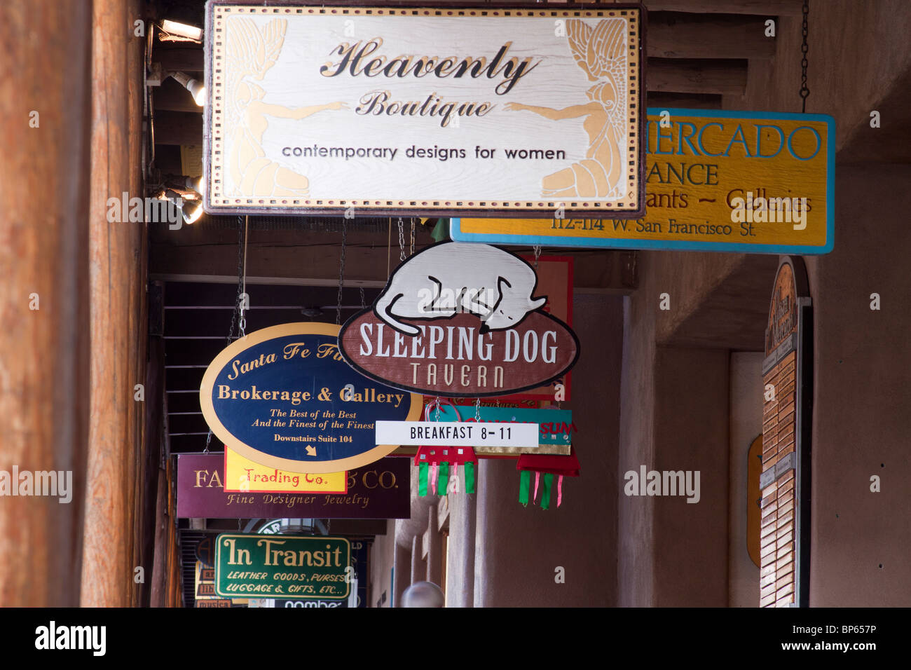 Colorful wood signs for galleries, shops and restaurants line a portico ...