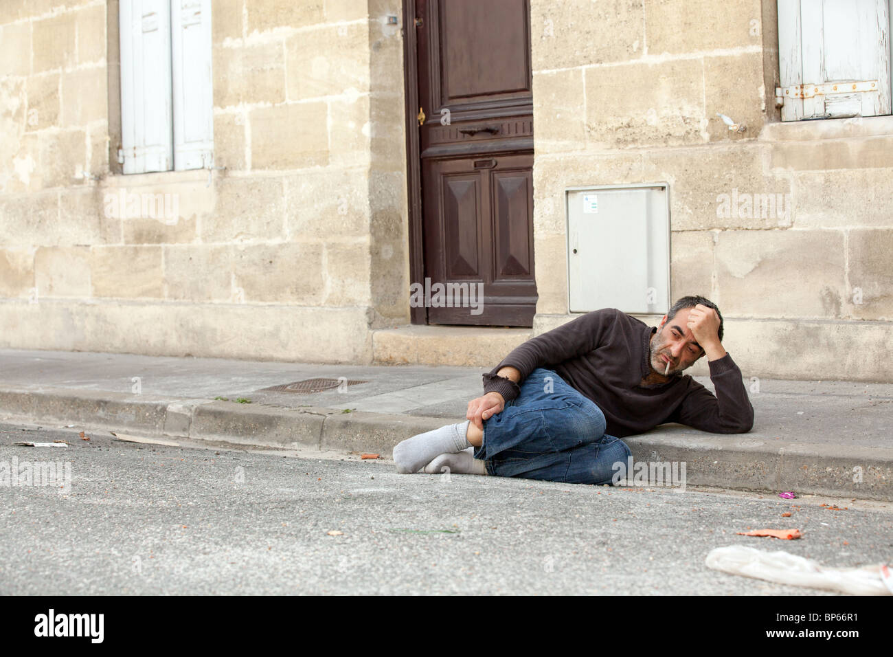 homeless man lying near house door in city street Stock Photo - Alamy