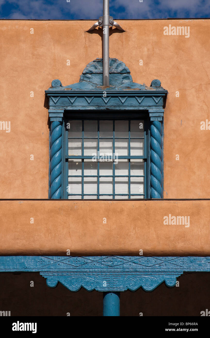 Pueblo revival style building with turquoise window decoration and ...