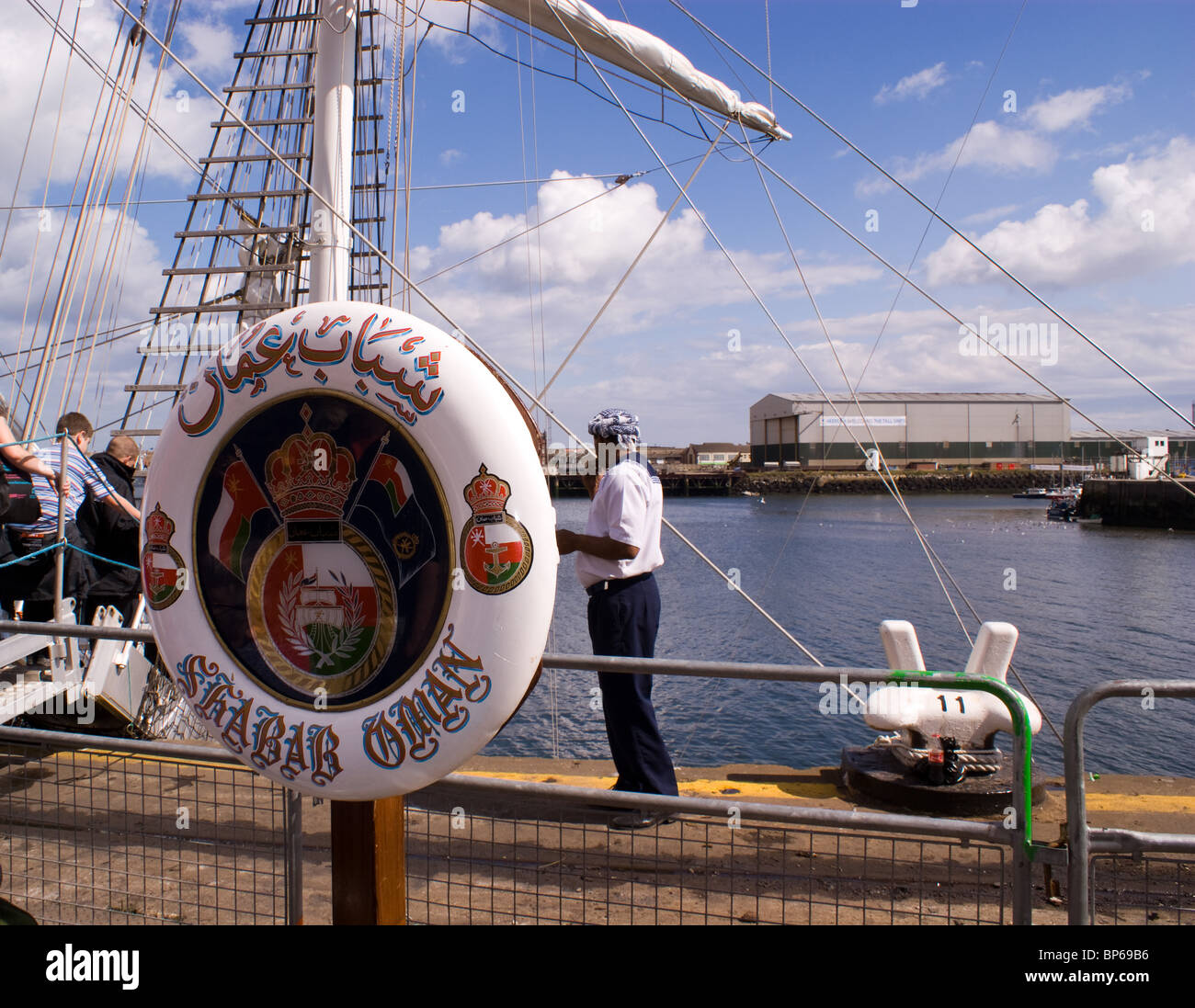 SAILOR WATCHING VISITORS BOARD THE TALL SHIP AT THE FINISH OF THE TALL ...