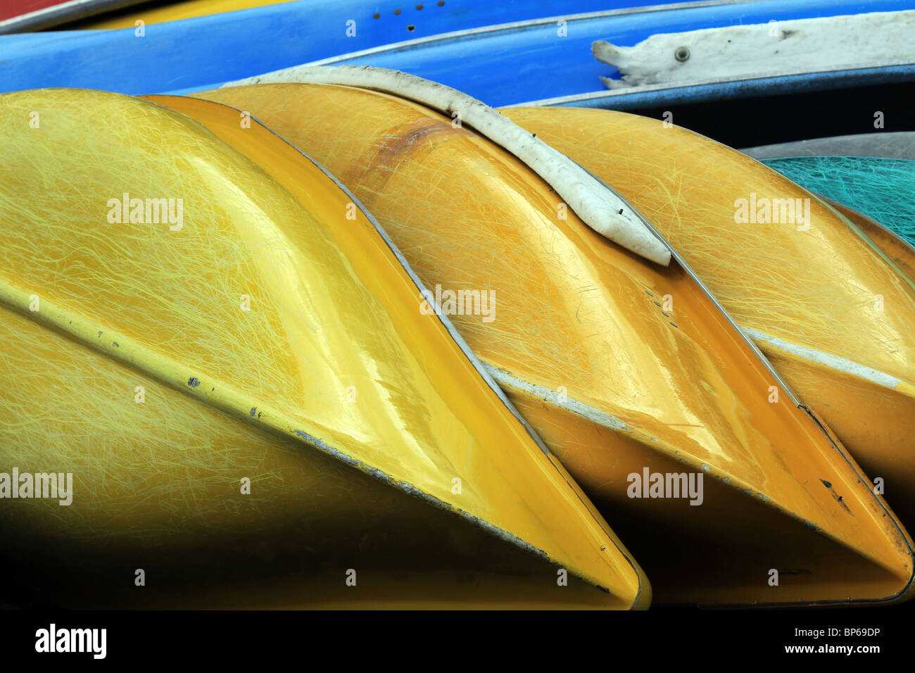 Colorful canoes laying on the beach ready to use. Bright colors closeup ...