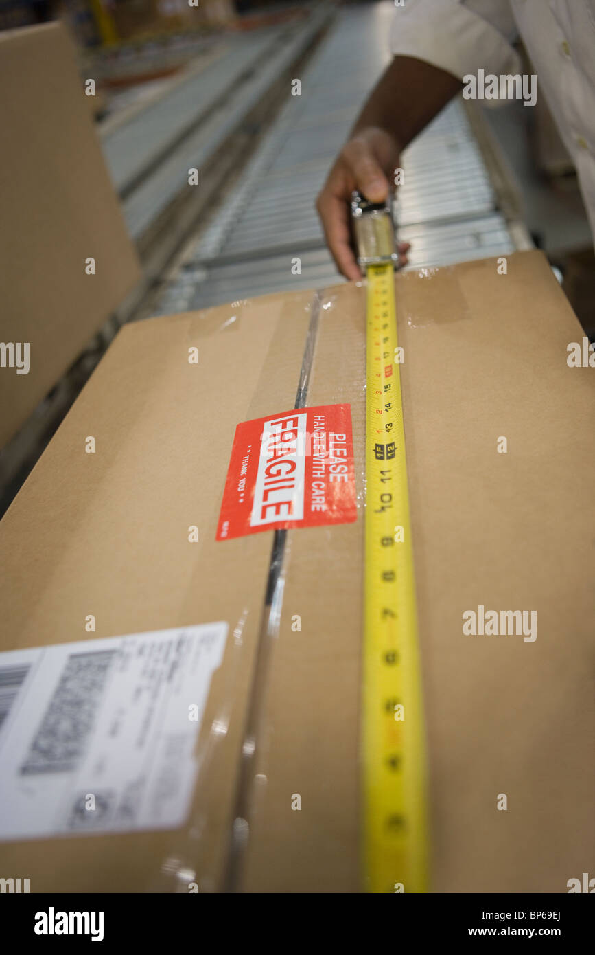 Man measuring cardboard box, close-up Stock Photo - Alamy