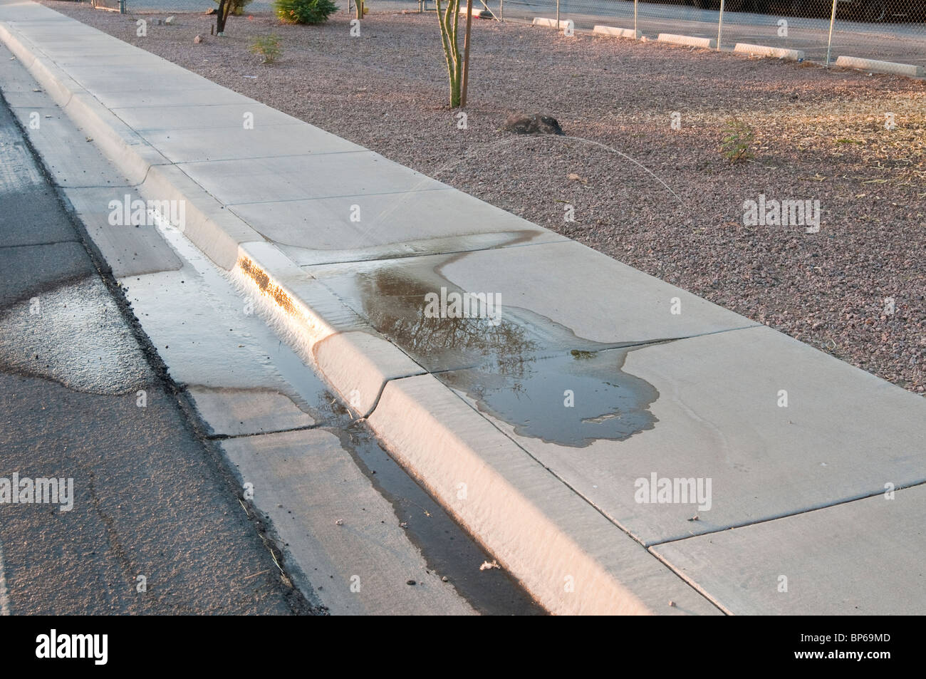 A faulty automatic drip irrigation system sprays water into the street ...