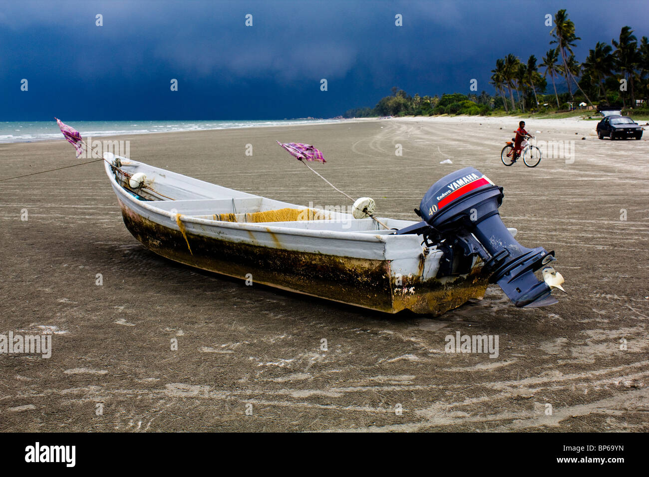 Fishing boat on the beach at Beserah, Kuantan, as a storm front ...
