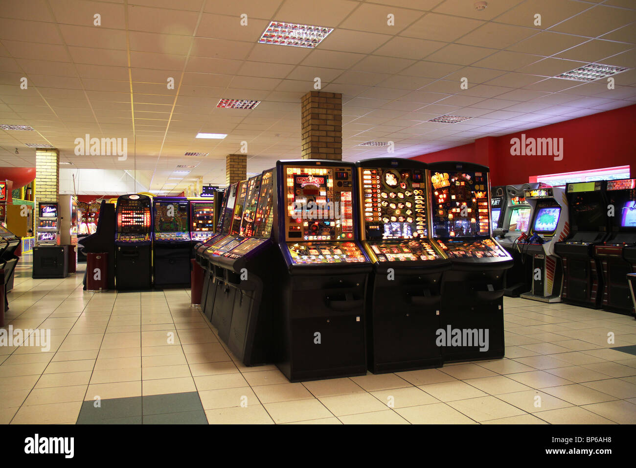 Empty amusement arcade showing gaming machines and tiled floor Stock ...
