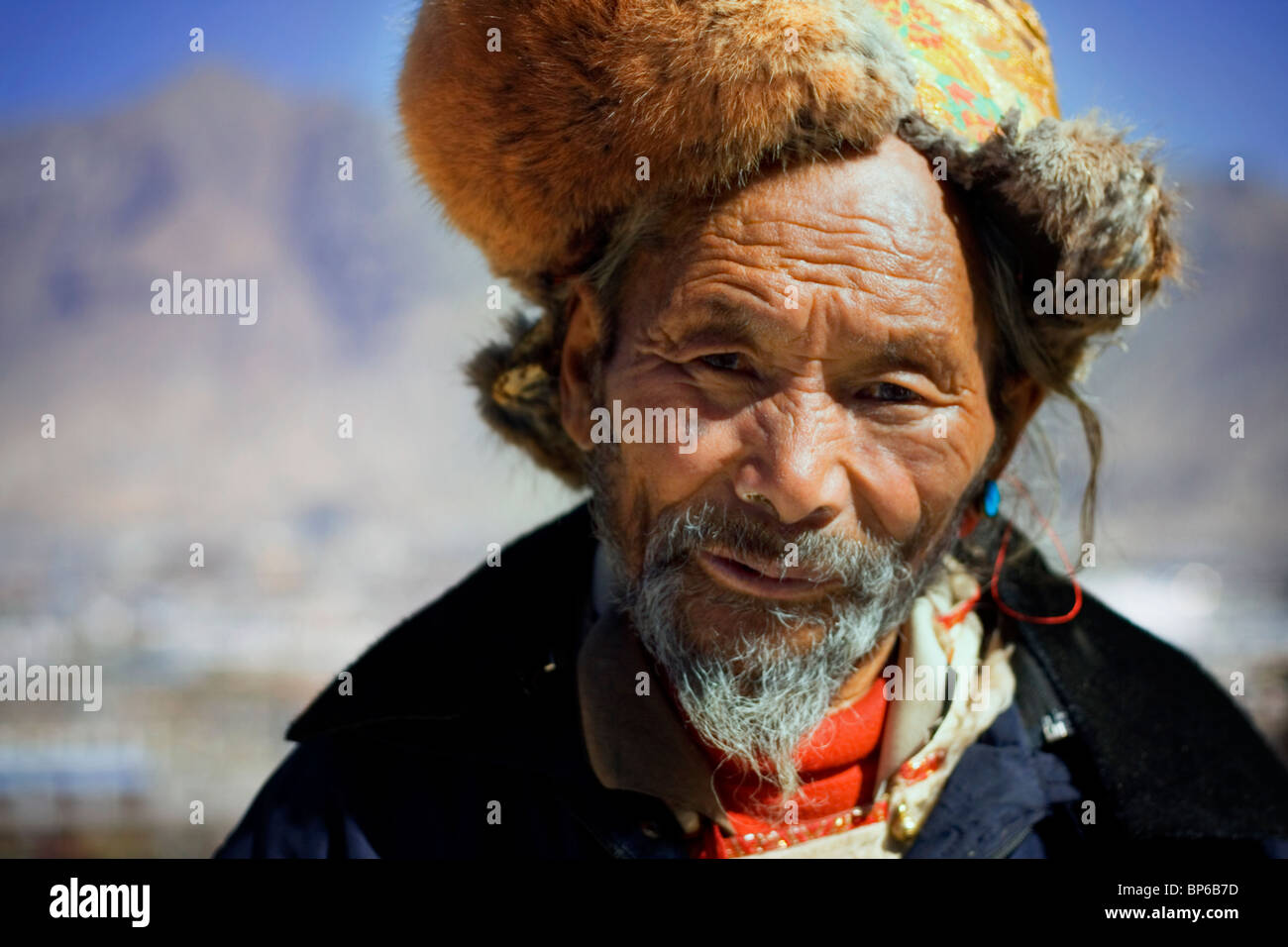 Portrait of a traditionally dressed man on the Potala Palace, in Lhasa ...