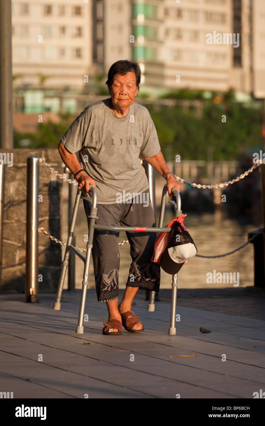 An aged person taking an early morning walk with a walking support ...