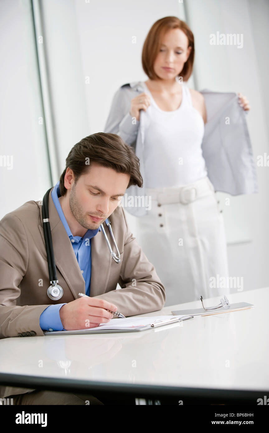 Woman getting dressed after treatment Stock Photo - Alamy