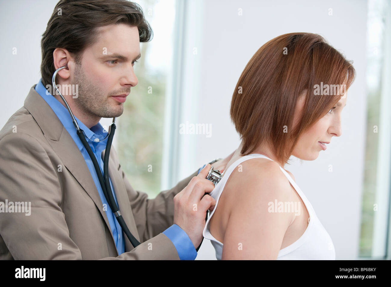 Doctor examining a patient with a stethoscope Stock Photo - Alamy