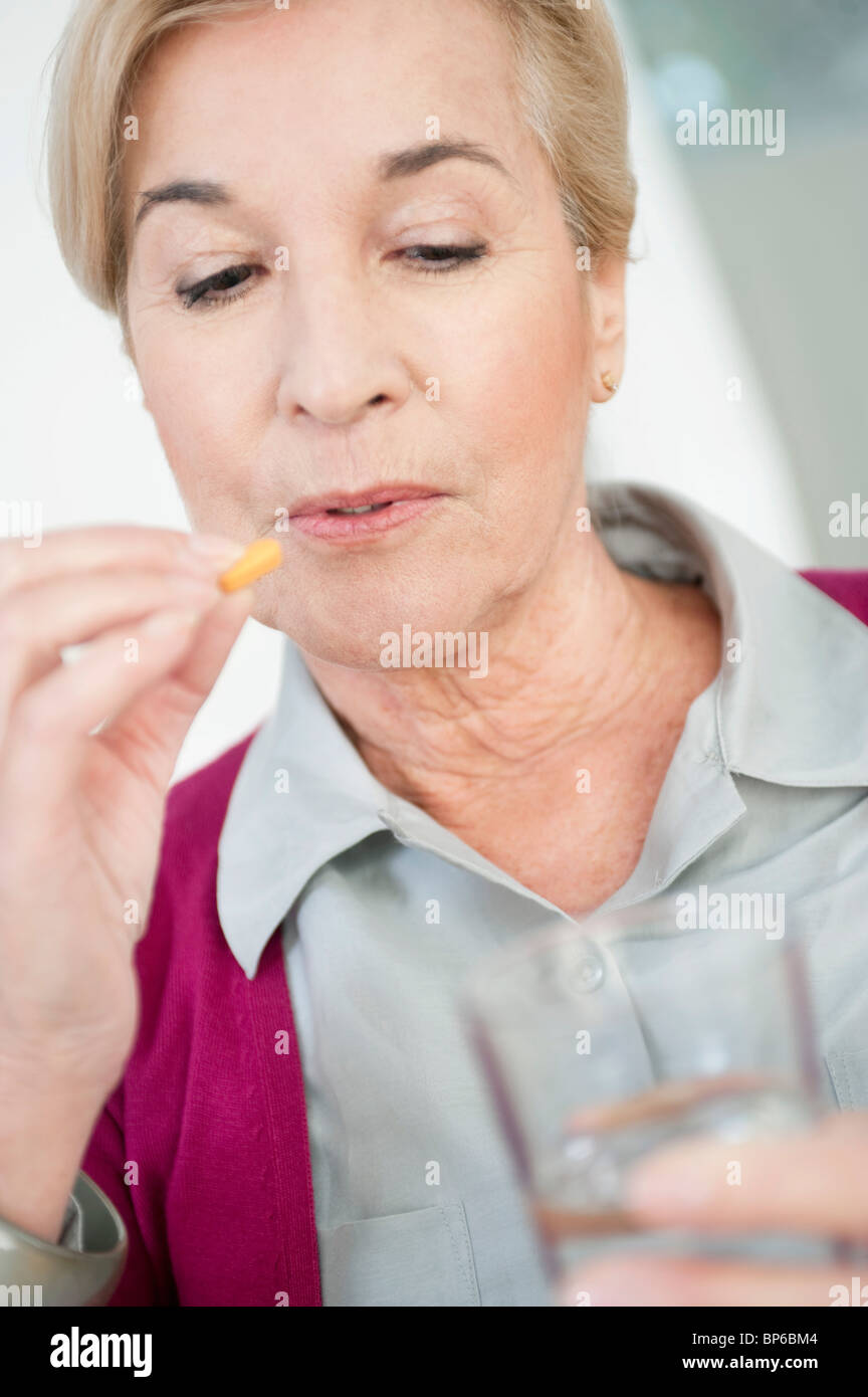 Woman taking a capsule Stock Photo - Alamy
