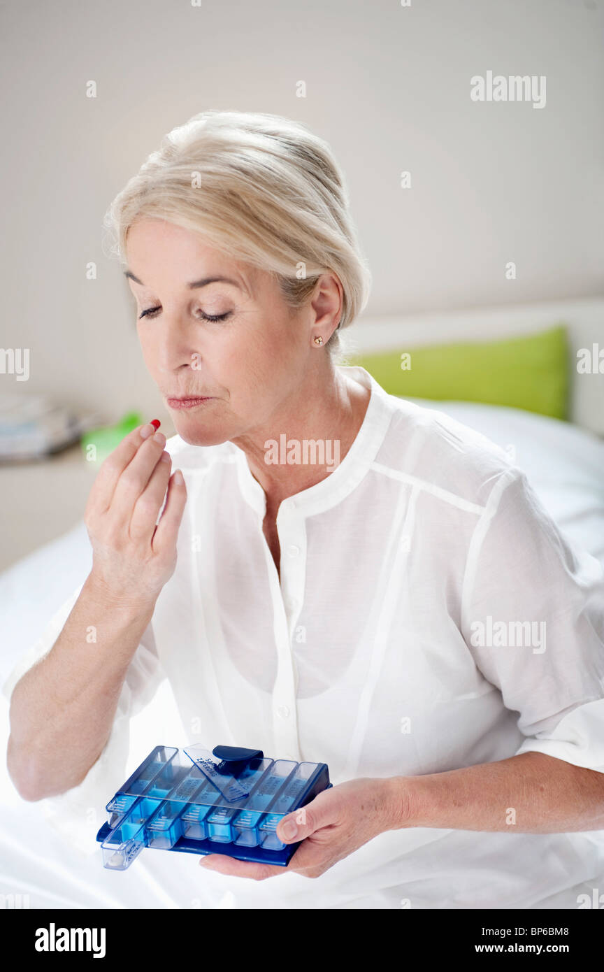 Woman taking a capsule Stock Photo - Alamy
