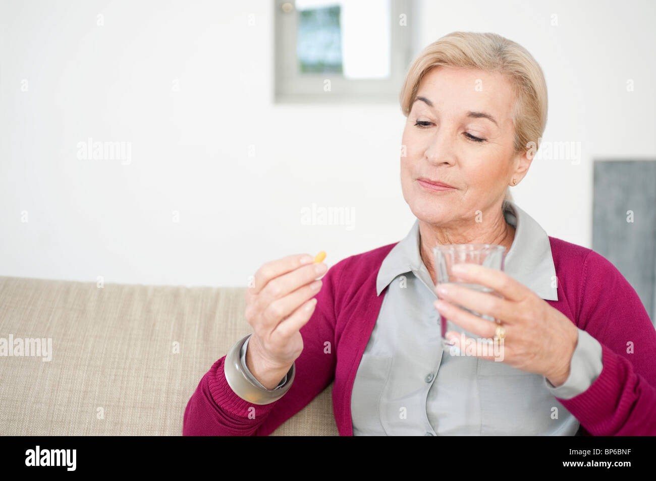 Woman taking a capsule Stock Photo - Alamy