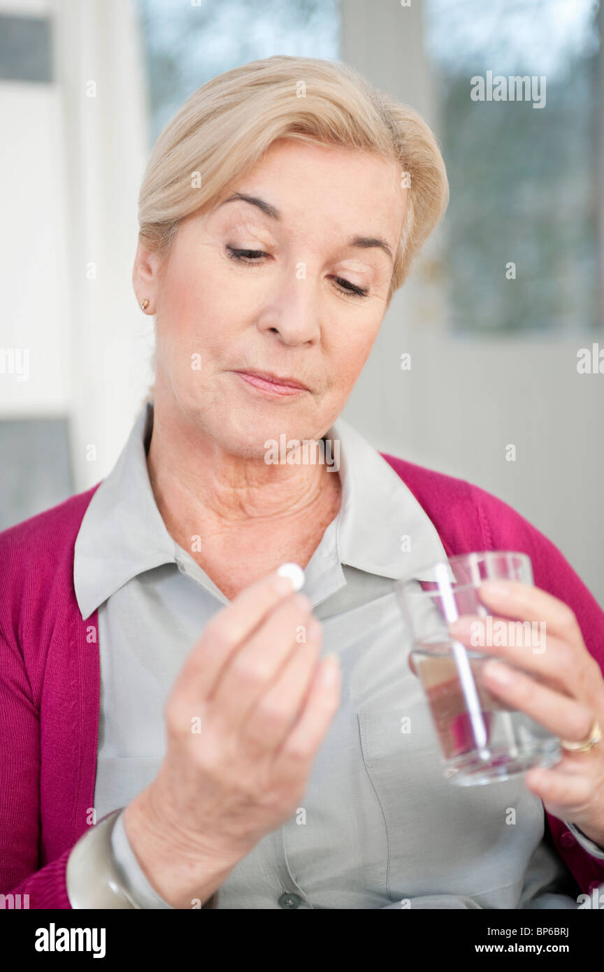 Close-up of a woman taking a capsule Stock Photo - Alamy